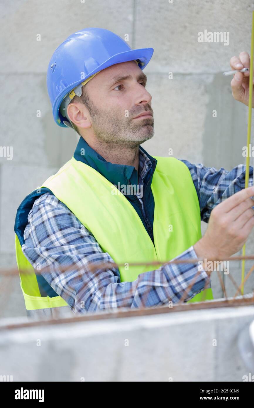 construction worker using measuring tape Stock Photo - Alamy