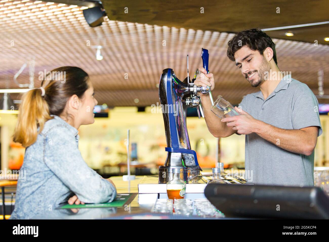 Smiling barman pouring beer hi-res stock photography and images - Alamy