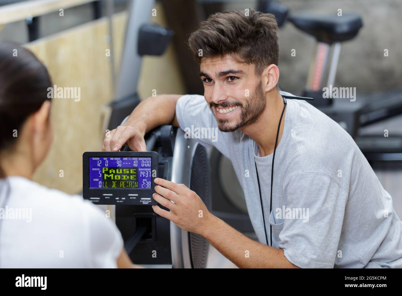 personal trainer explaining digital controls on exercise machine Stock ...