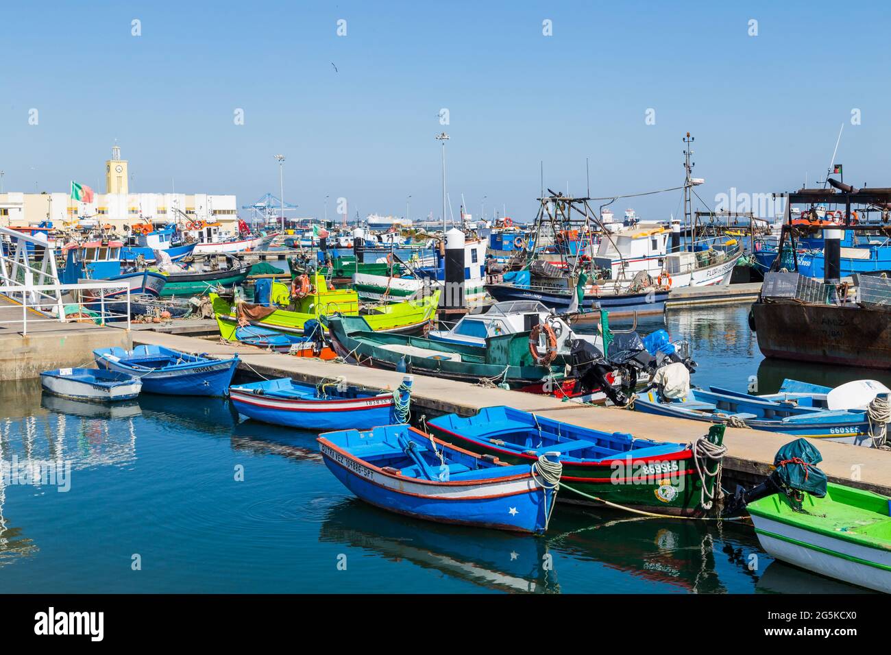 View of the small fishing port of Setubal with its typical blue boats ...
