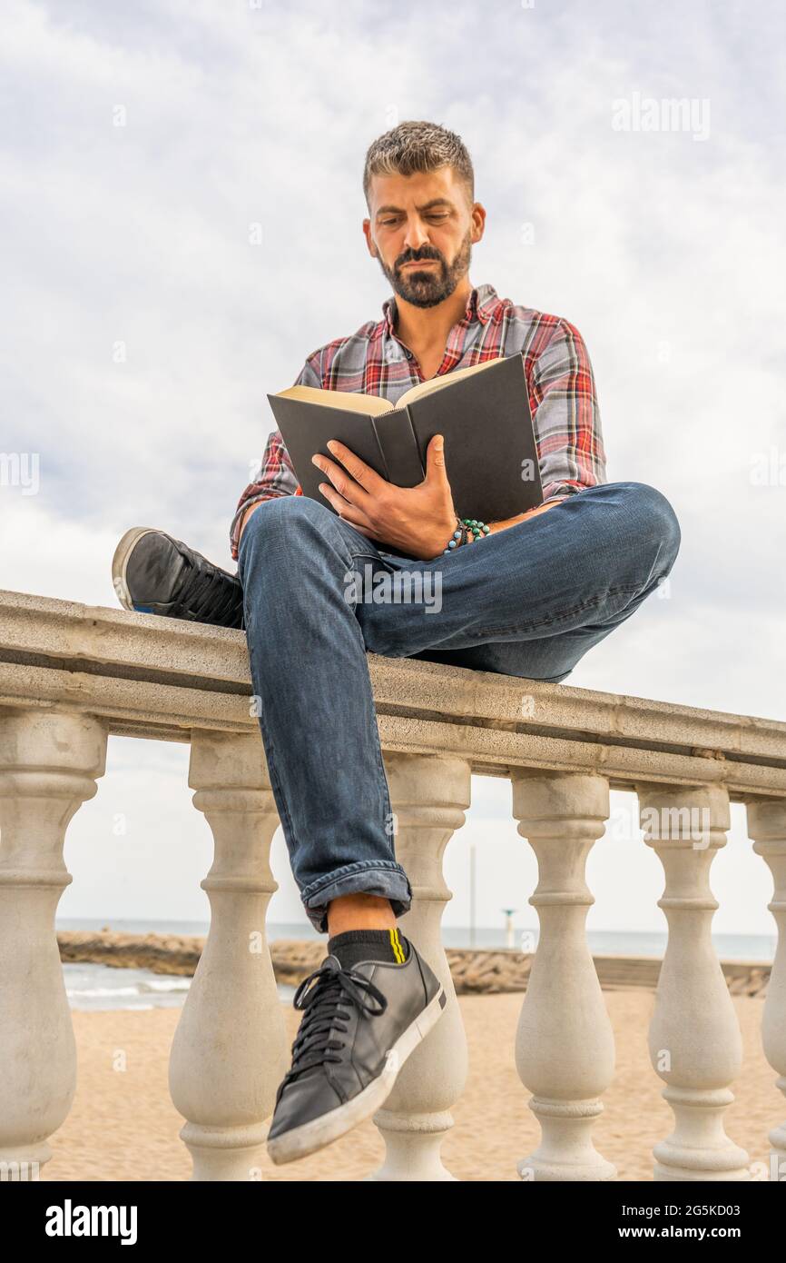 Hispanic man reading book outside hi-res stock photography and images ...
