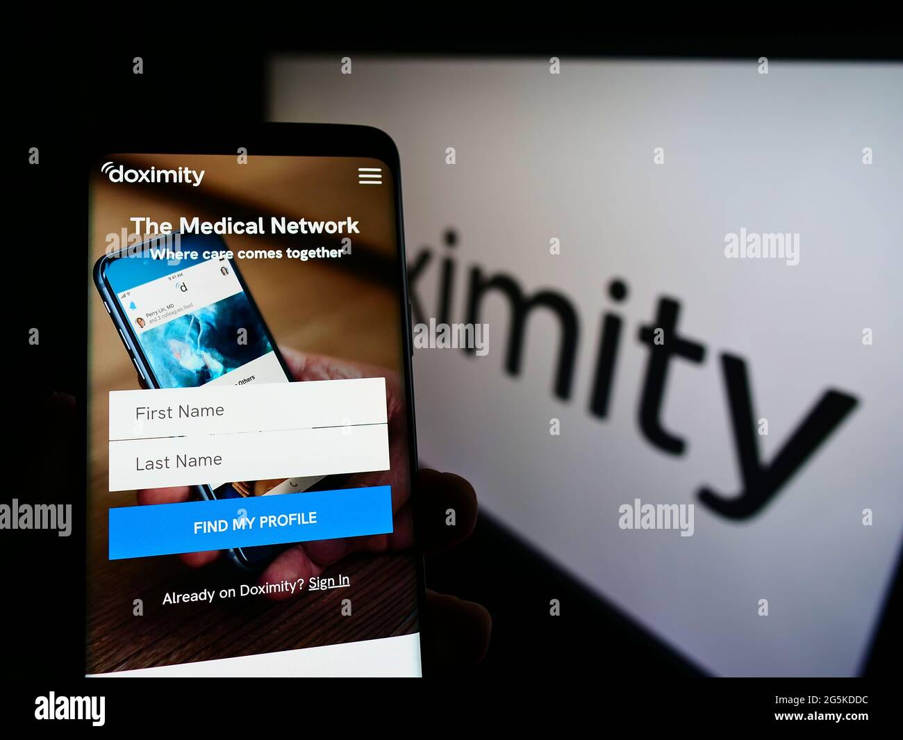 Person holding mobile phone with website of US medical networking ...