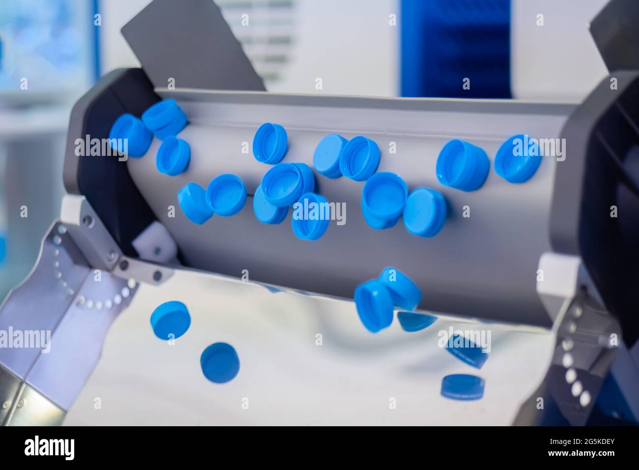 Production line - many blue plastic bottle caps falling from conveyor ...