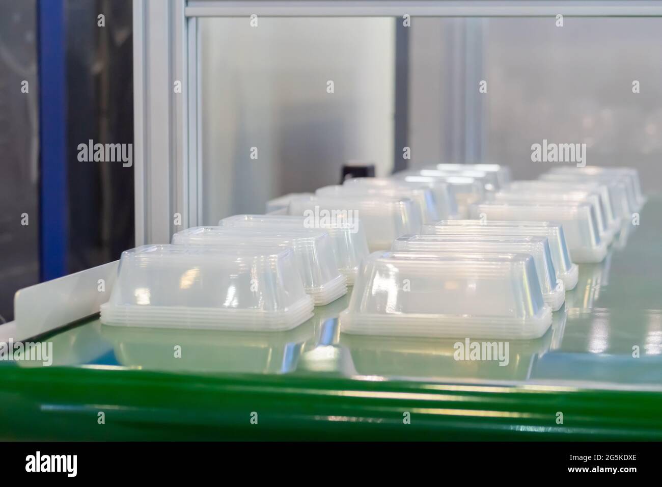 Empty food containers on conveyor belt of plastic injection molding ...