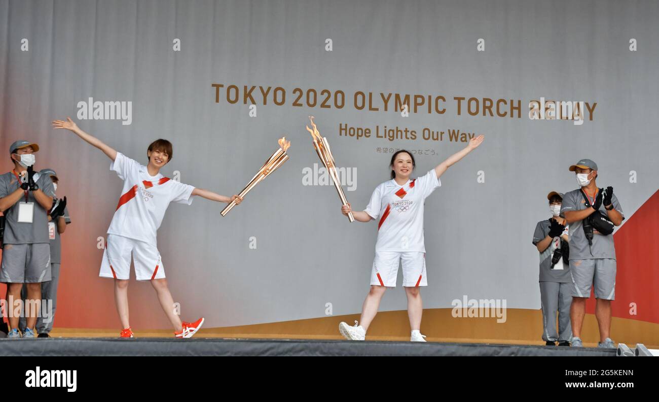 Fujisawa, Japan. 28th June, 2021. A torchbearers pose for cameras ...