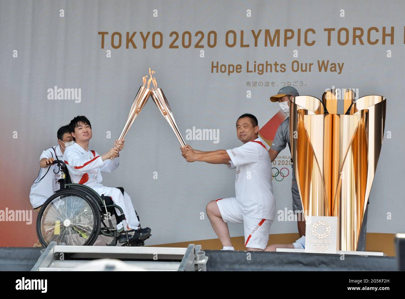 Fujisawa, Japan. 28th June, 2021. A torchbearers pose for cameras ...