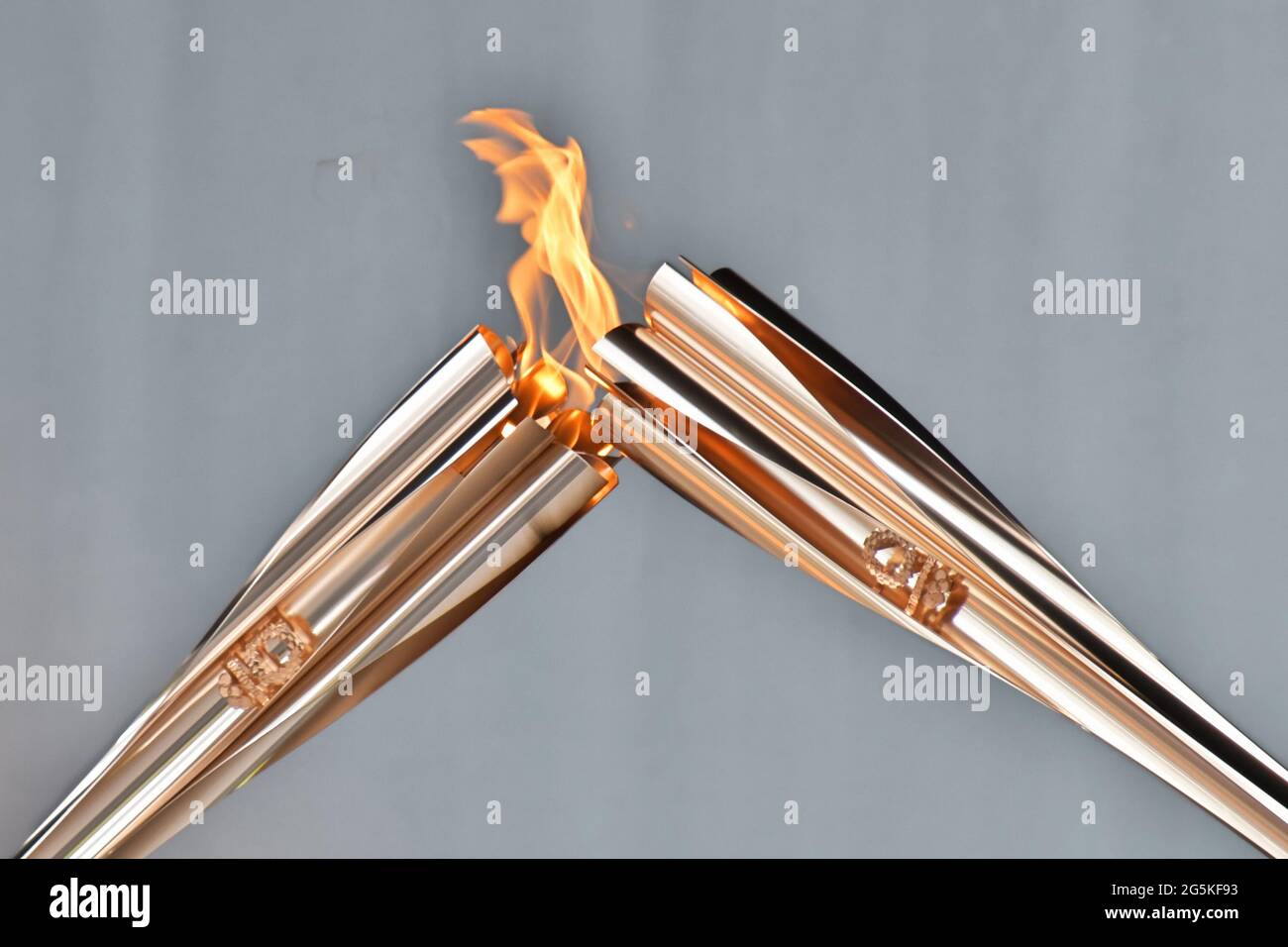 Fujisawa, Japan. 28th June, 2021. A torchbearer passes the flame to the ...