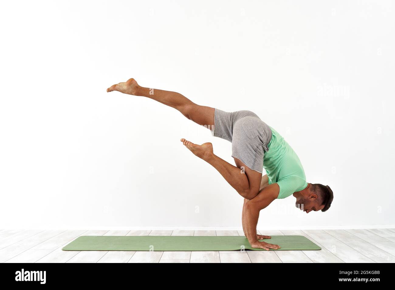 Man practicing balance yoga pose on white studio background Stock Photo ...