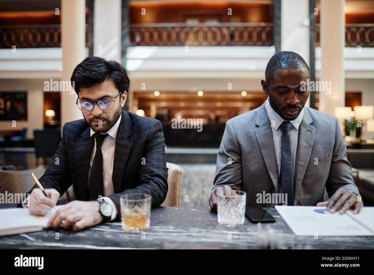Front view portrait of two successful business people working in hotel ...