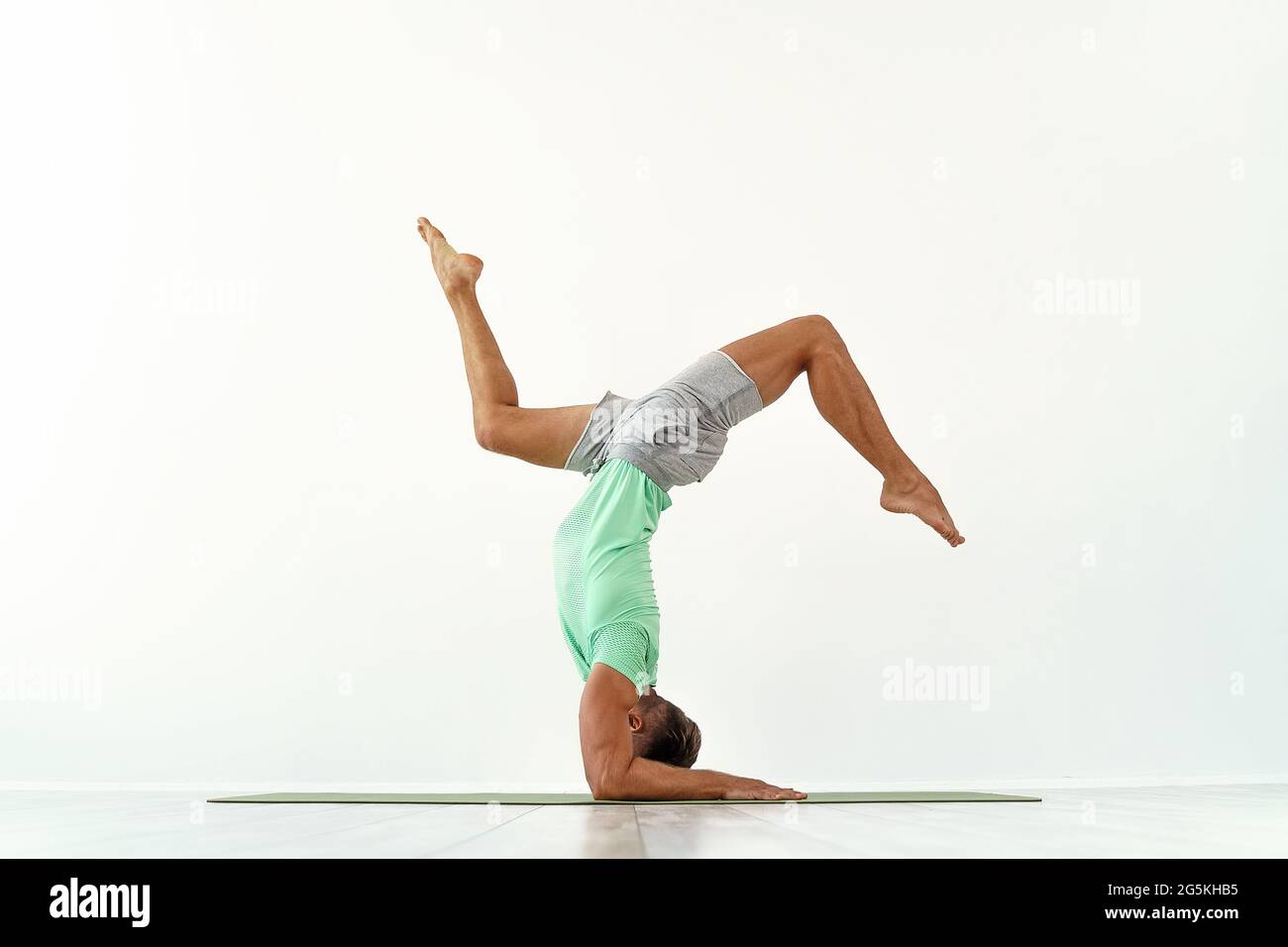 Man practicing balance yoga pose on white studio background Stock Photo ...