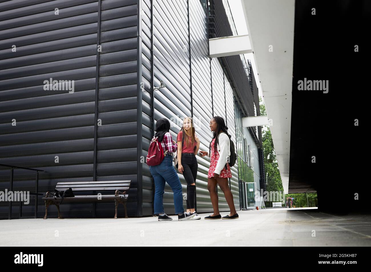 Three students hanging out around their campus Stock Photo - Alamy
