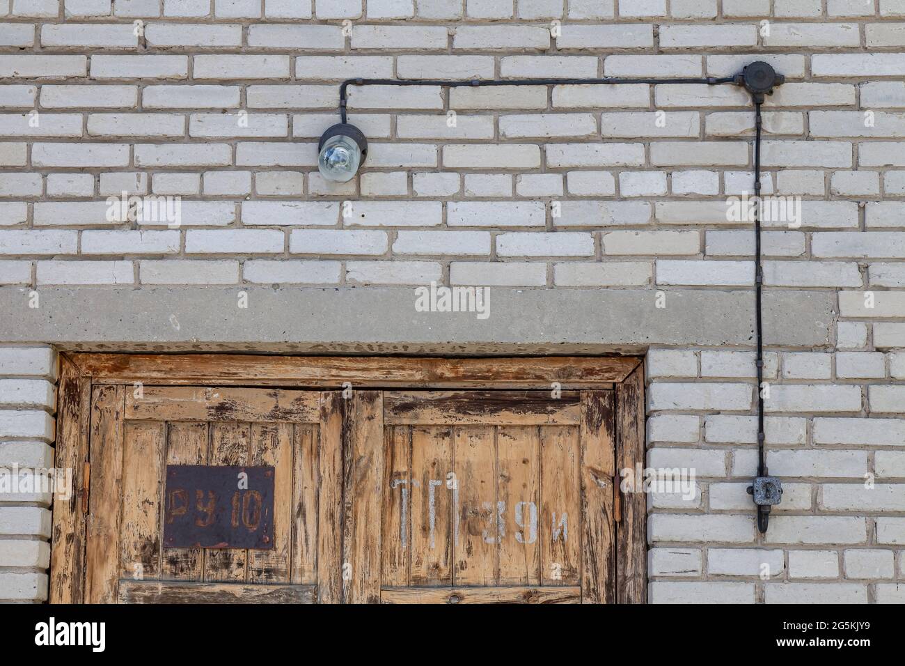old metallic and glass night security lamp over a painted wooden door ...