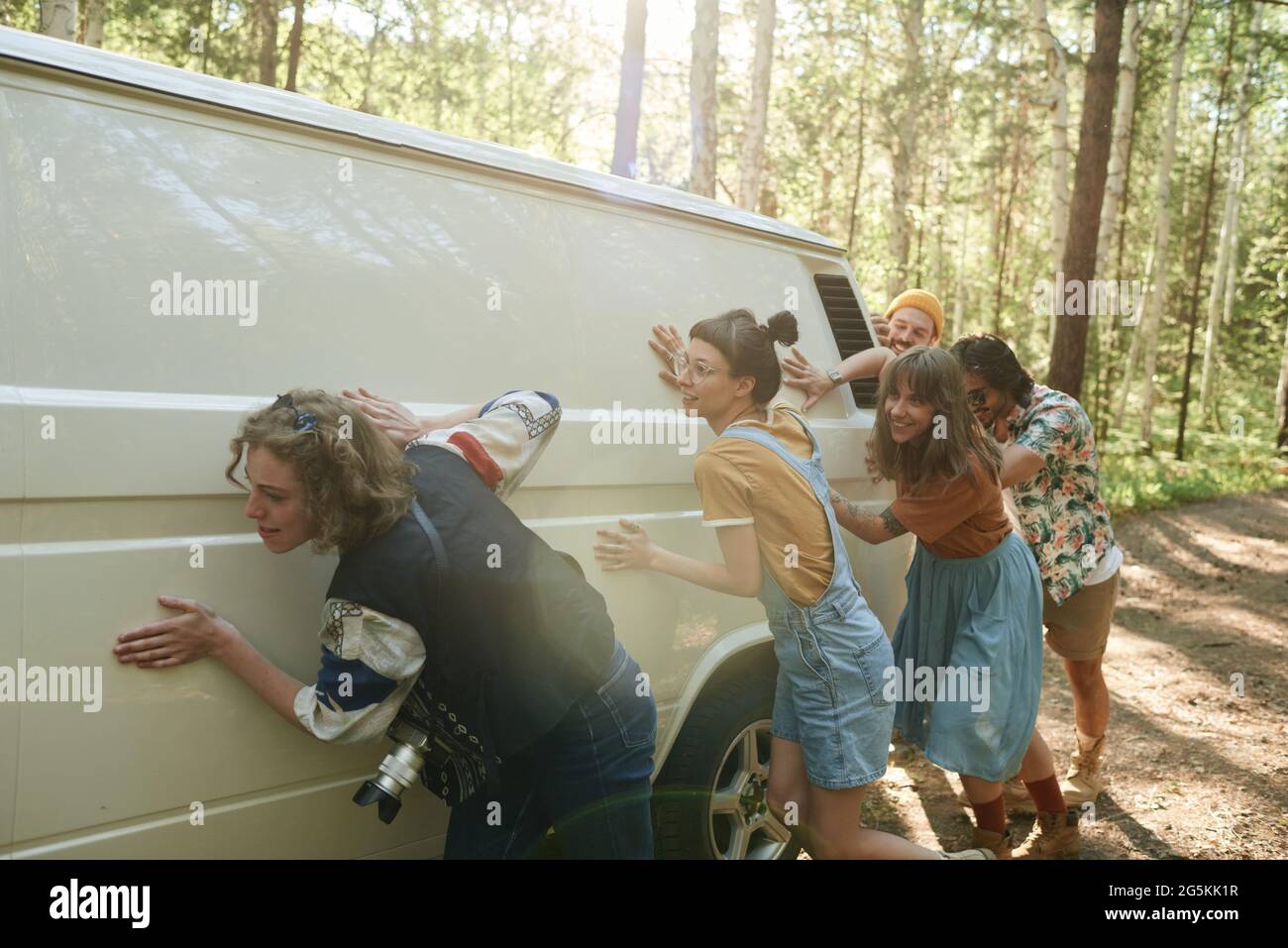 Group of people pushing the van together during journey on the nature ...