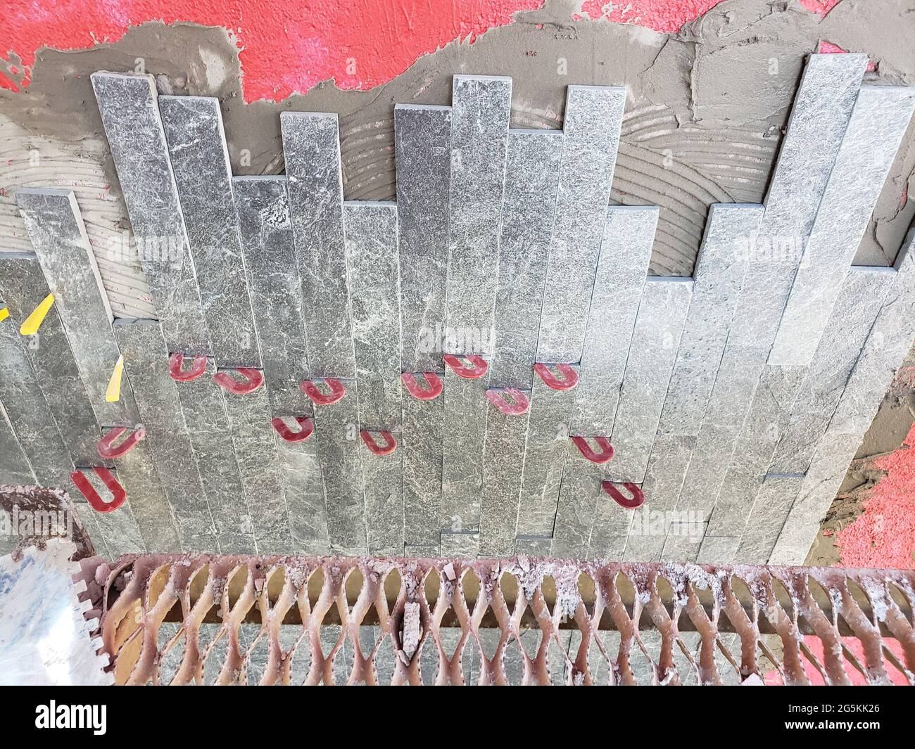 Red Shims for tile installation in the wall Stock Photo - Alamy