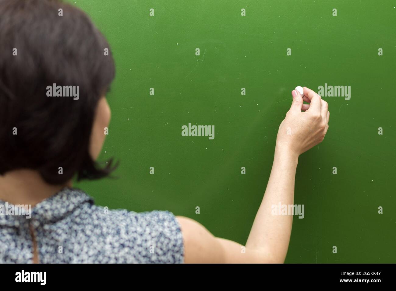 A female teacher writes with chalk on blackboard close up Stock Photo ...