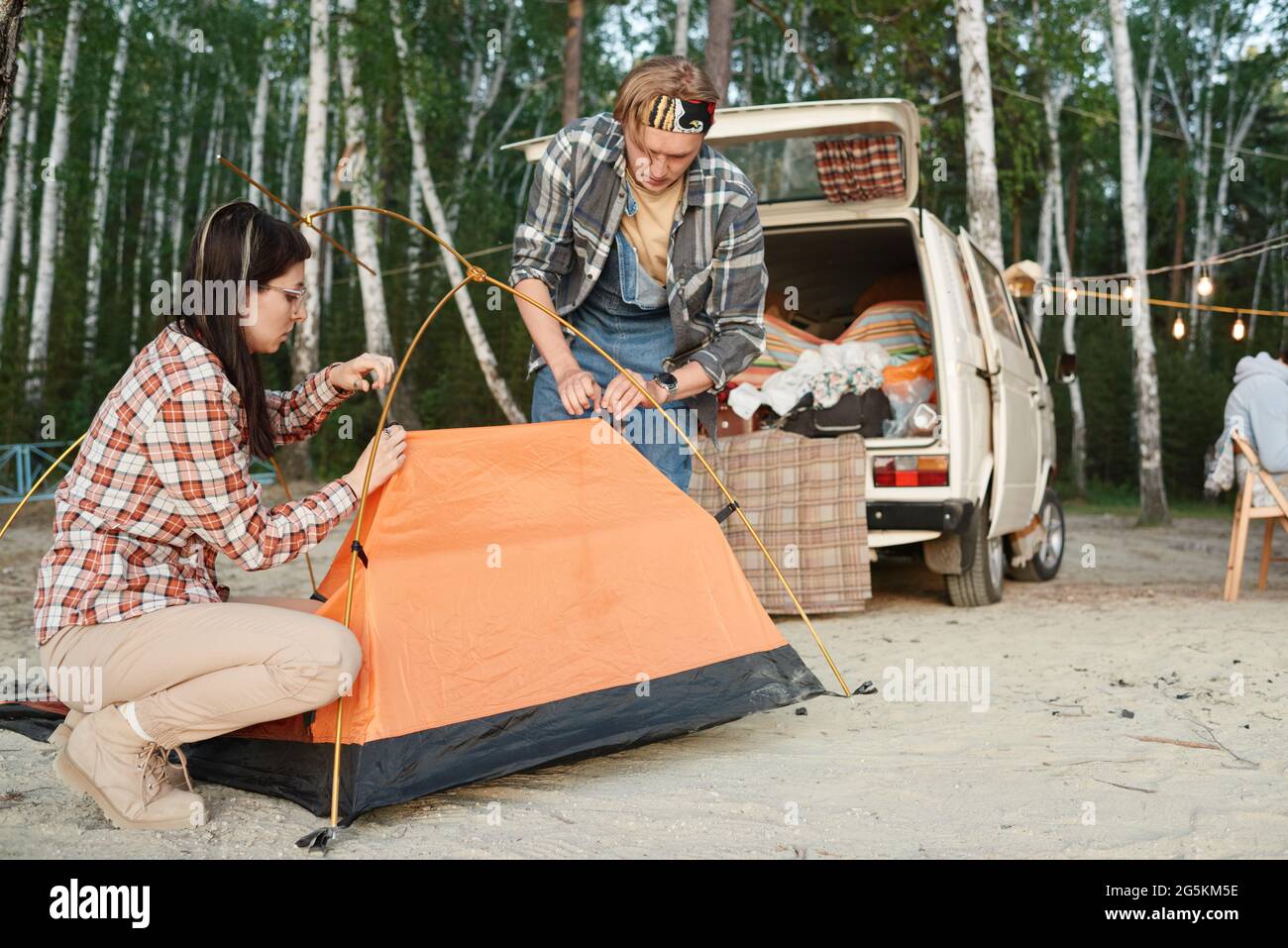 Young people setting up tents together they arranging camp in the ...