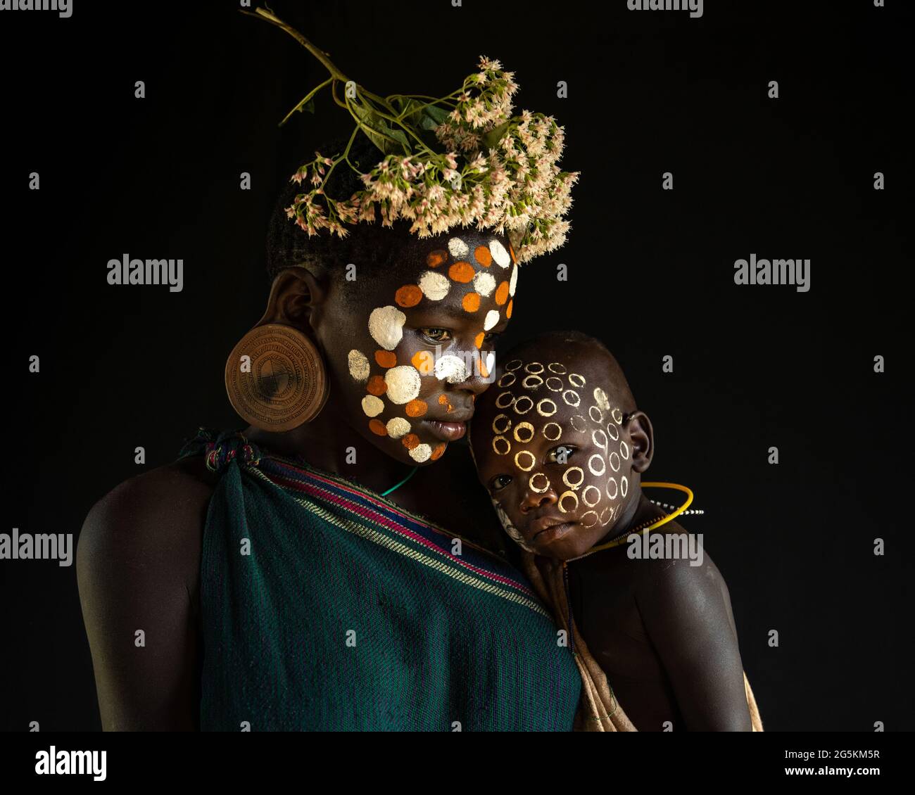 A Suri mother and her child pose with matching dotted face-paint. OMO ...