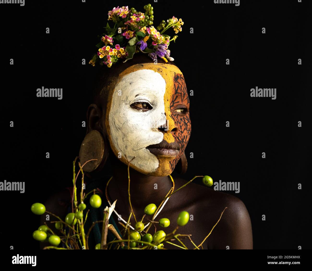 Face-paint covers this Suri girl's face as she holds onto a delicate ...