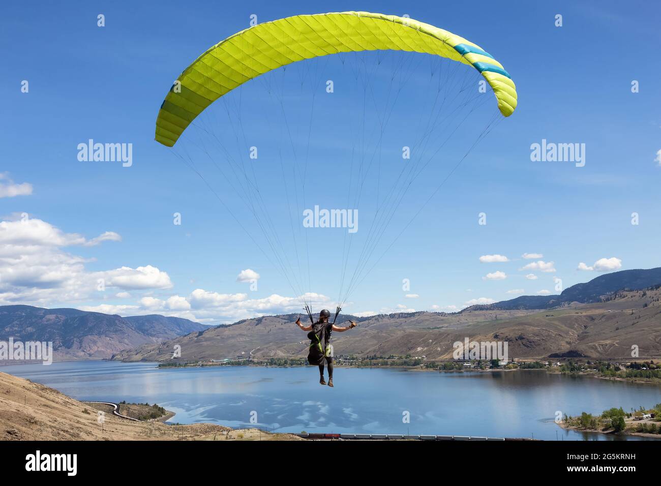 Adventurous Woman Learning to fly a Paraglider around the mountains ...