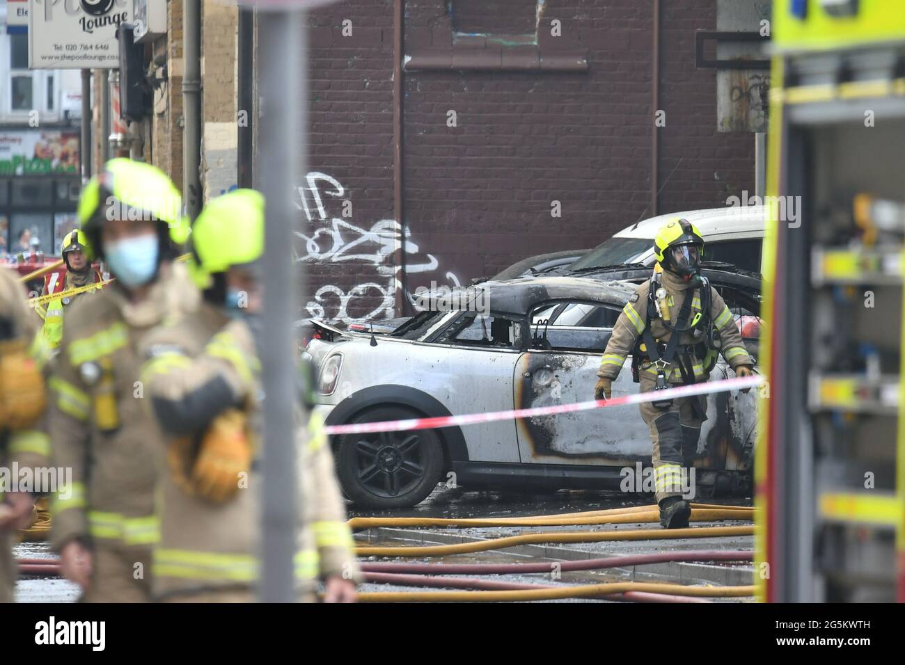 Firefighter walks beside a fire damaged car at the scene of a fire in ...