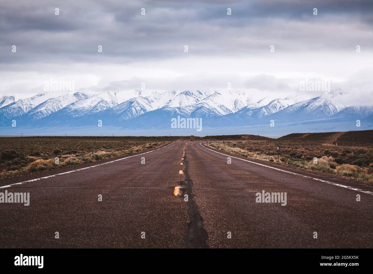 Empty desolate lonely desert road with mountains in distance, Nevada ...