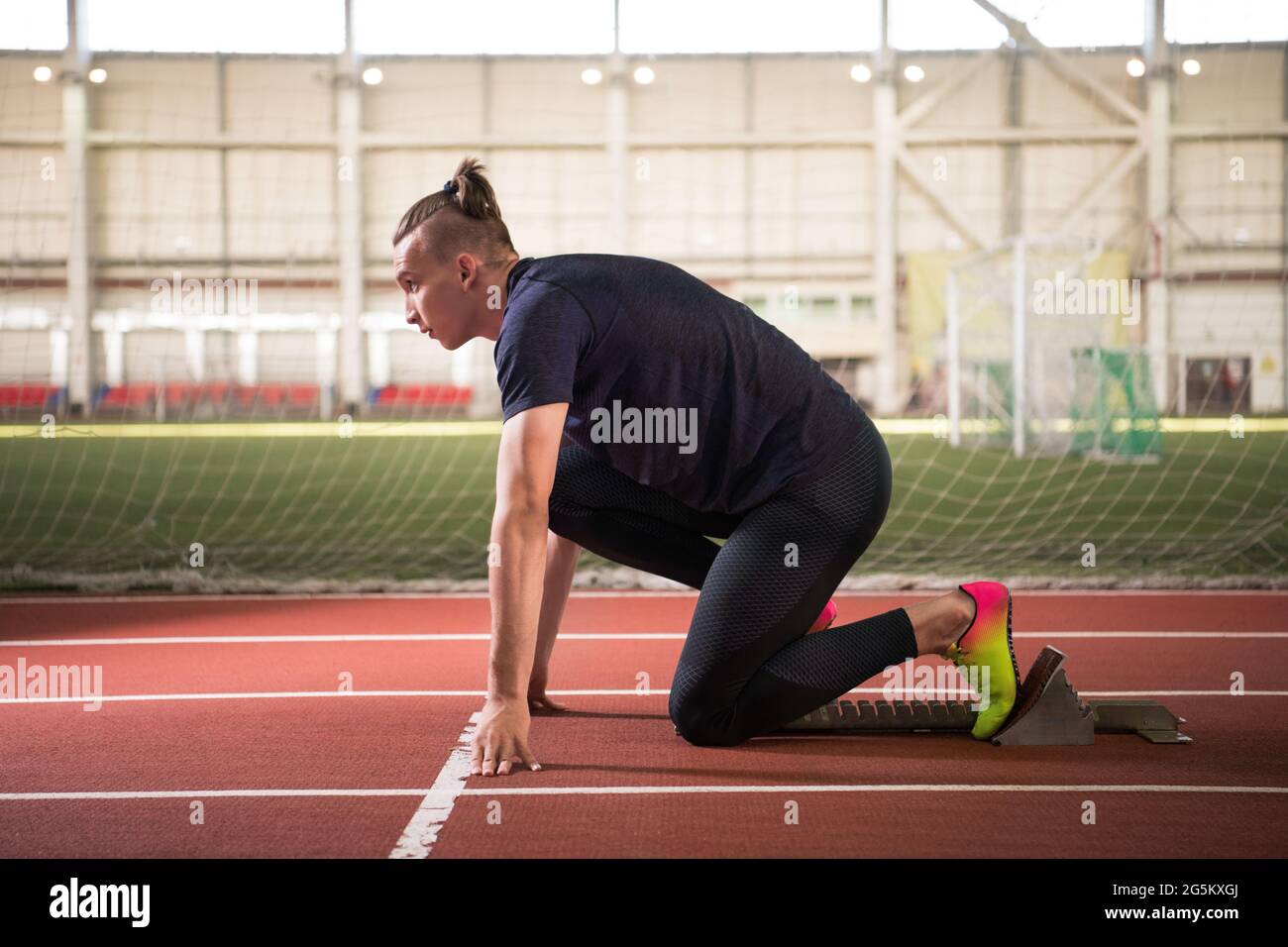 Strong male athlete preparing to run from crouch start position on ...