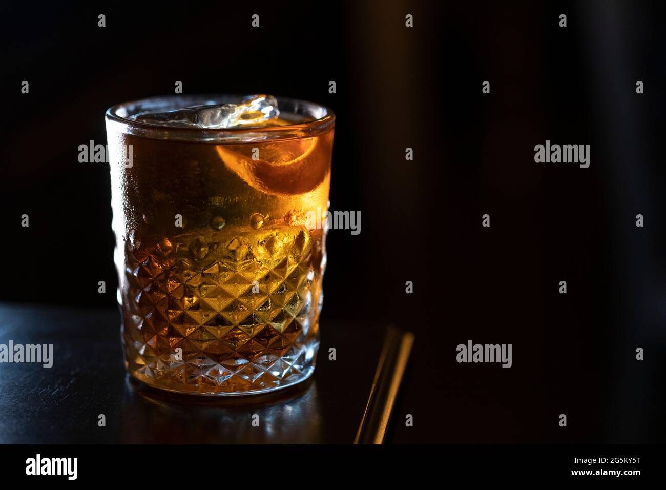 Cocktail in decorative glass light filtered through on edge of table ...