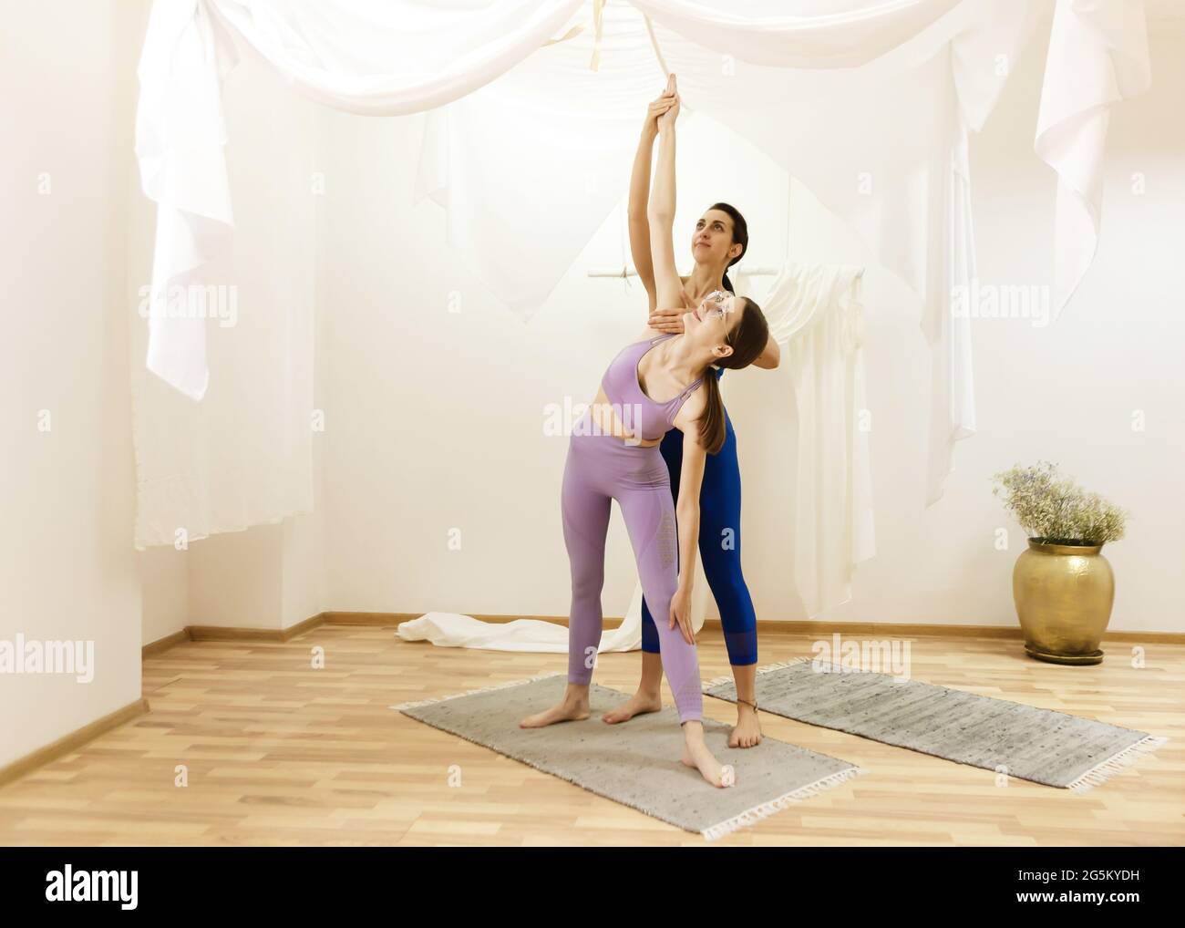 young girl is engaged with a yoga coach in the studio Stock Photo - Alamy