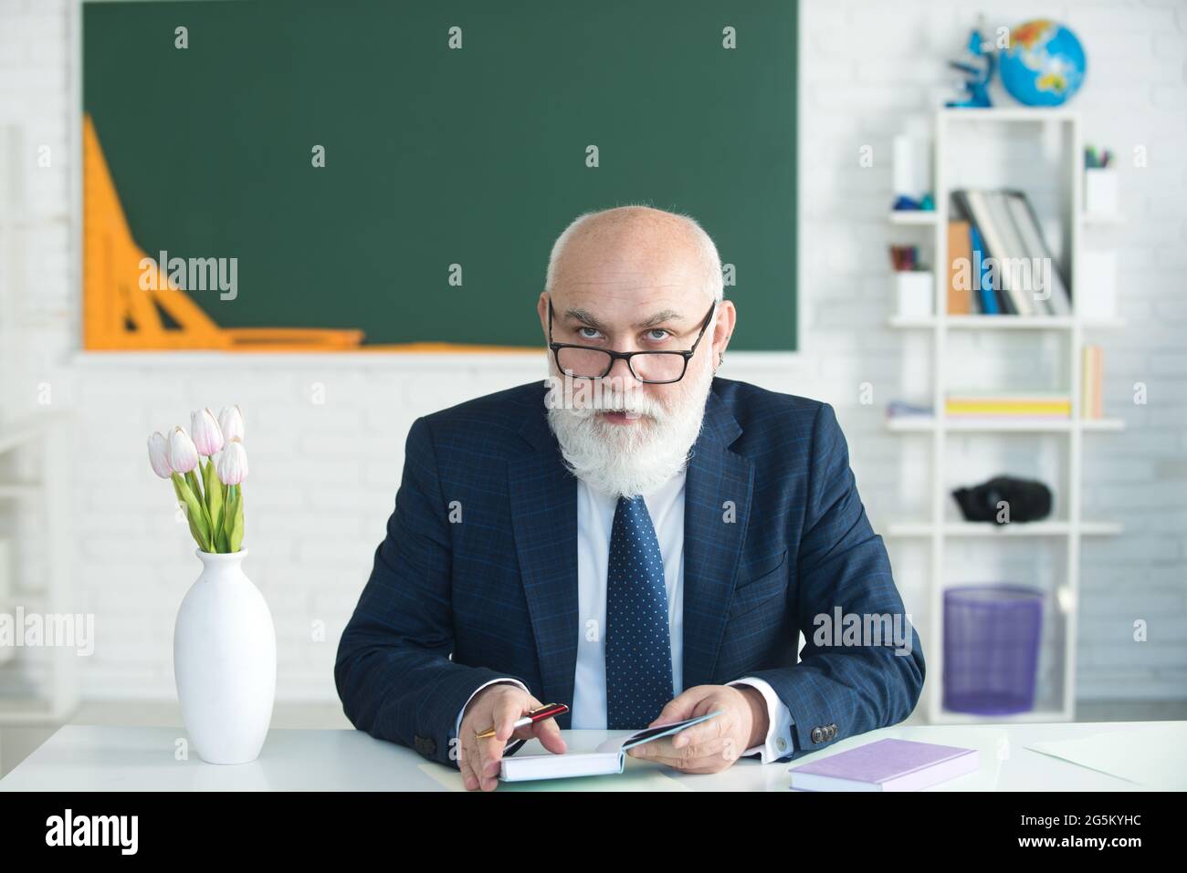 Elderly Senior professor reading an old book in the library, knowledge ...