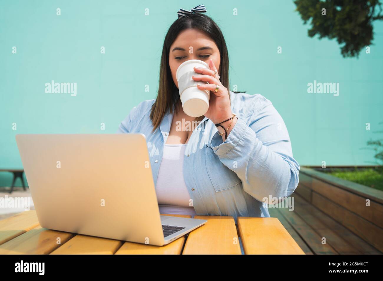 Young plus size woman using laptop at coffee shop Stock Photo - Alamy