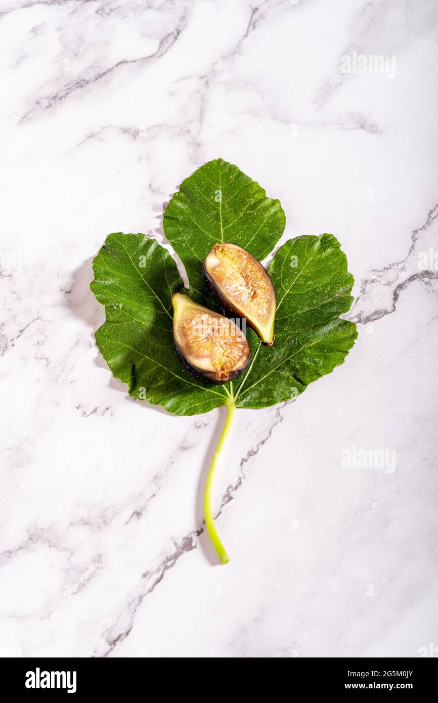 Bright photography of figs and a fig leaf on a marble table Stock Photo ...