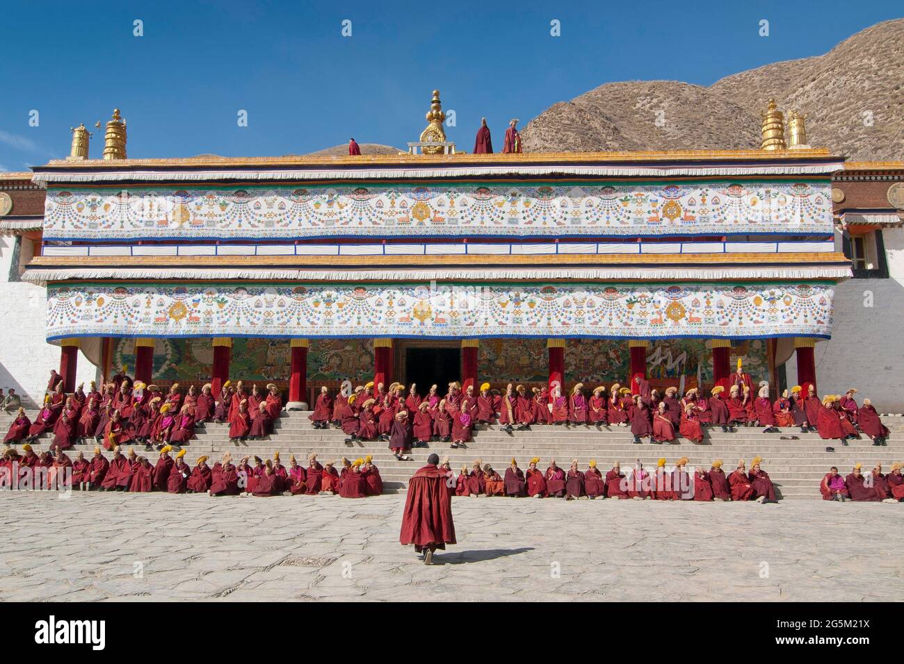 Tibetan monks in monk's robe and yellow cap of the Buddhist Gelukpa ...