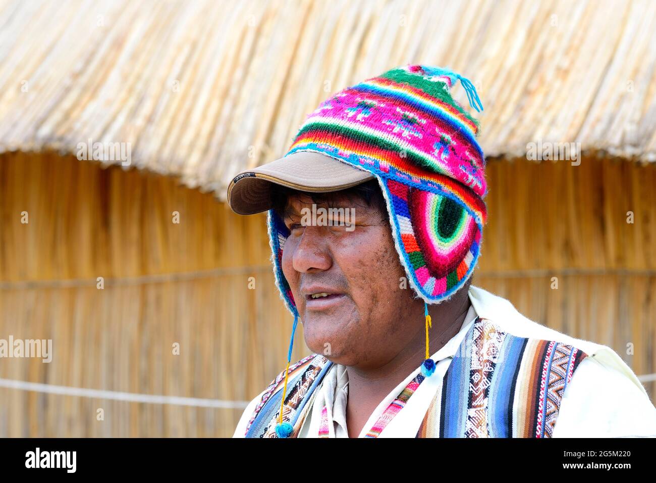 Man with colorful knitted cap on a floating island of the Uro, Lake ...