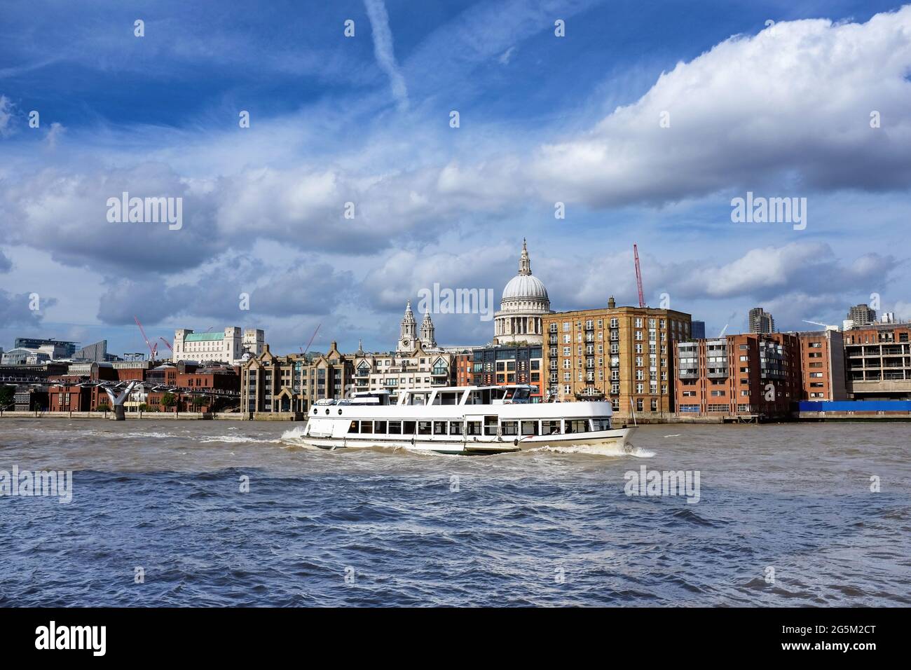 Pleasure boat sailing down the Thames River, London. The Millennium ...
