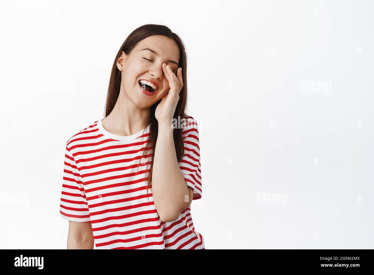 Happy beautiful woman laughing, touching face with closed eyes and ...