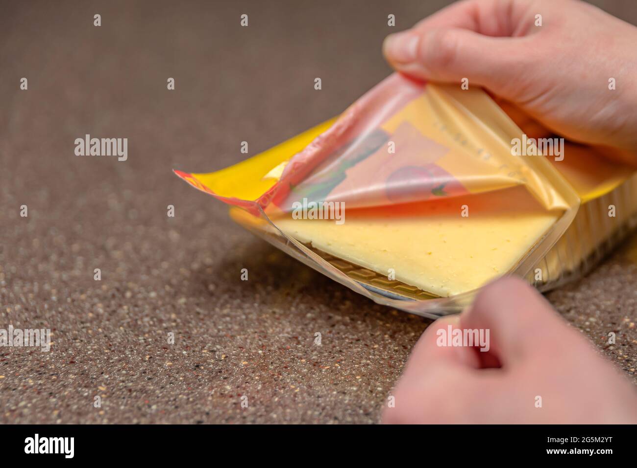 Opens a bag of sliced cheese, a woman opens a bag of cheese, pieces of ...