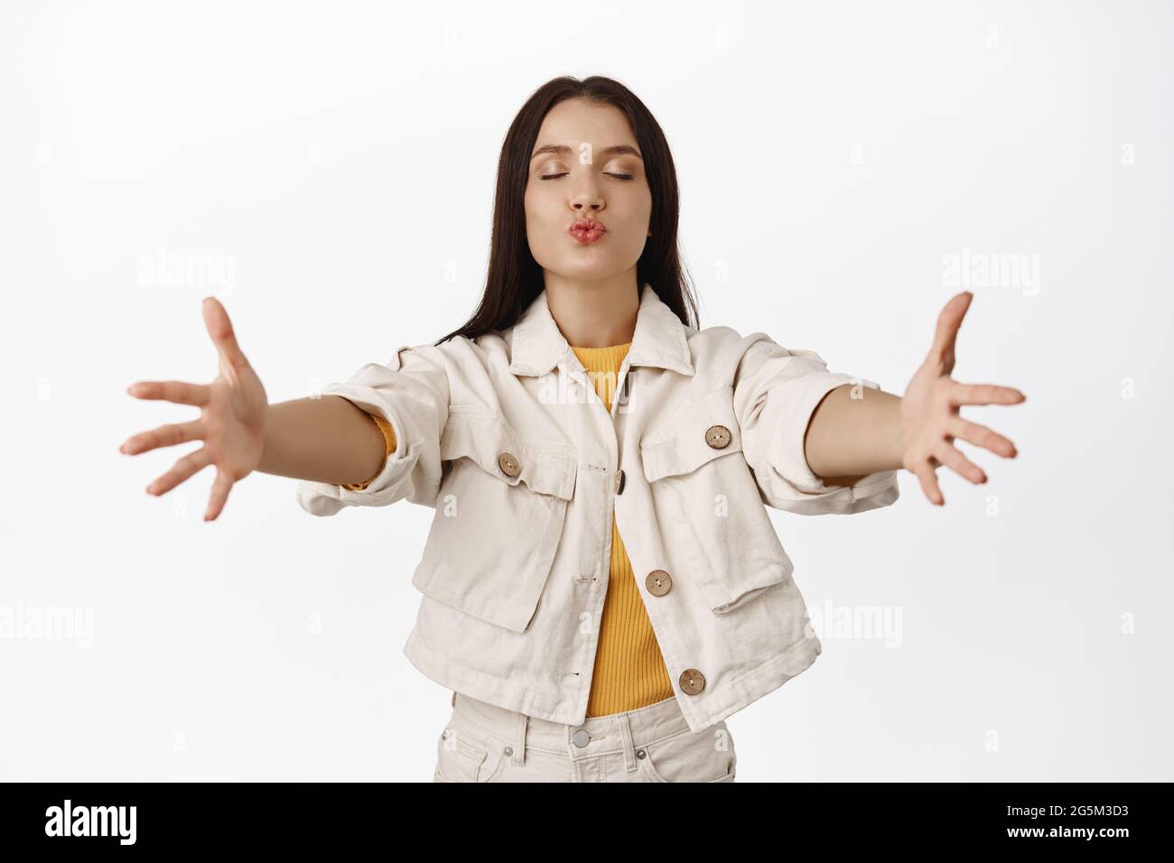 Romantic woman reaching hands, stretching out arms with closed eyes and ...