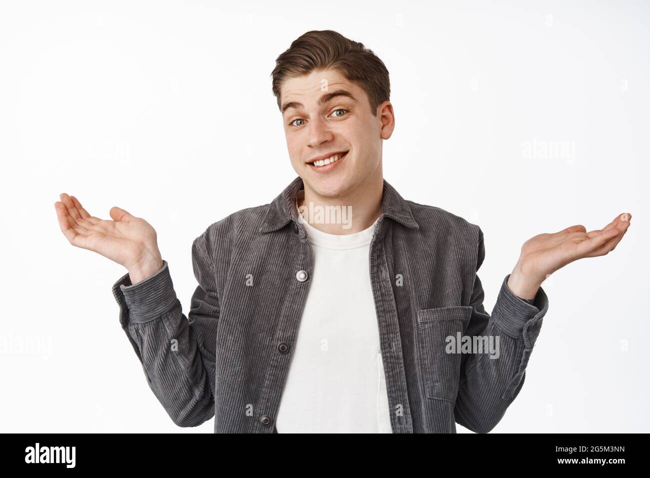 I dont know. Cute smiling young man shrugging, boy looks clueless ...