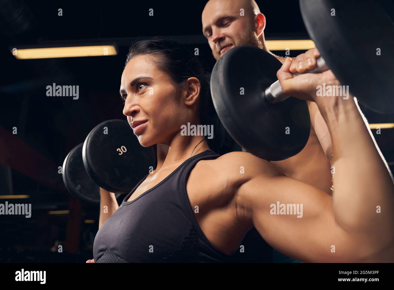 Strong female working out at the gym with her partner Stock Photo - Alamy