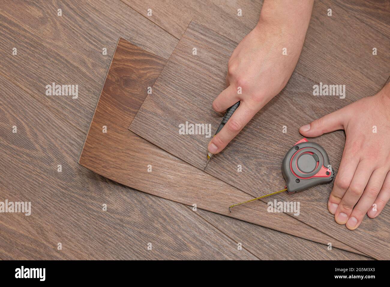 The process of laying vinyl flooring in public places, cutting brown ...