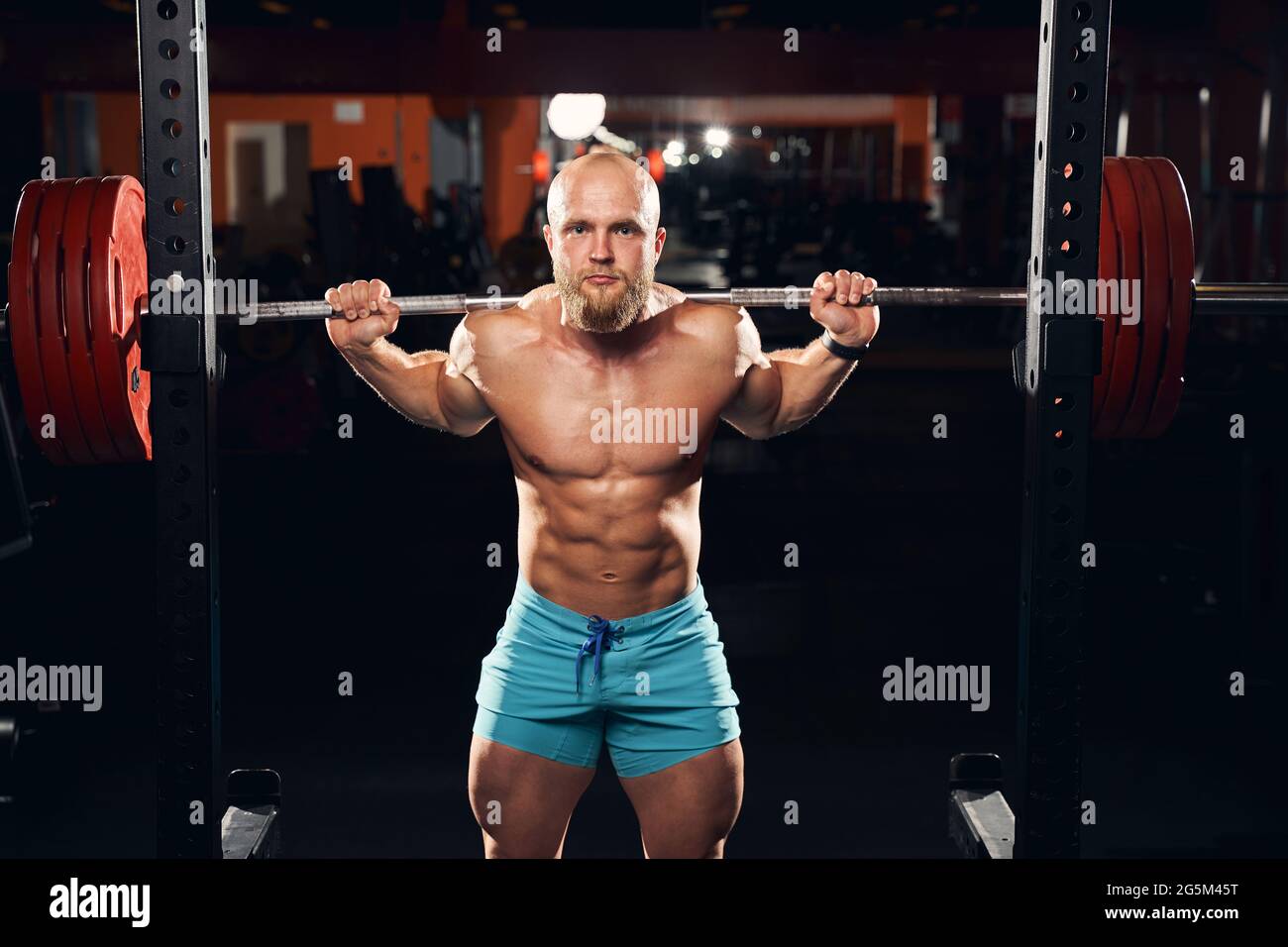 Strong man holding a barbell with weights on his shoulders Stock Photo ...