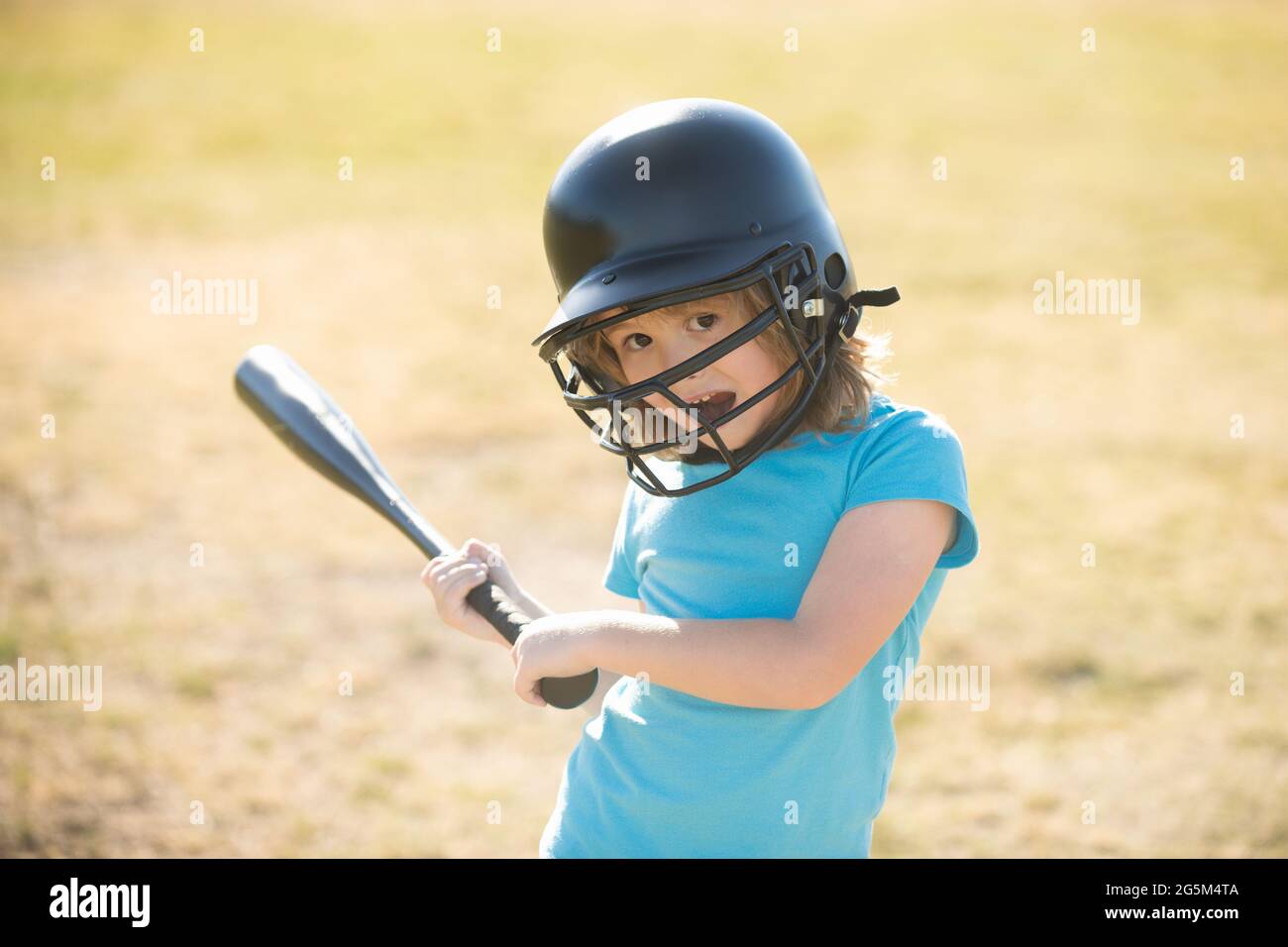 Funny boy kid holding a baseball bat. Pitcher child about to throw in ...