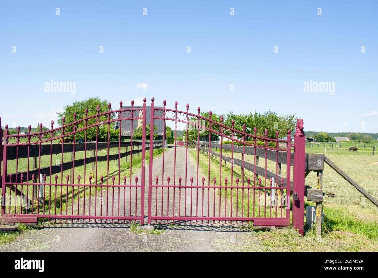 Closed red steel gate that gives access to a farm Stock Photo - Alamy