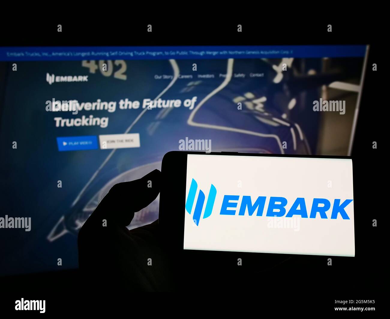 Person holding smartphone with logo of US autonomous driving company ...