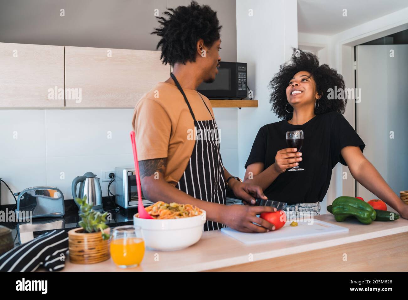 Afro couple cooking together in the kitchen Stock Photo - Alamy