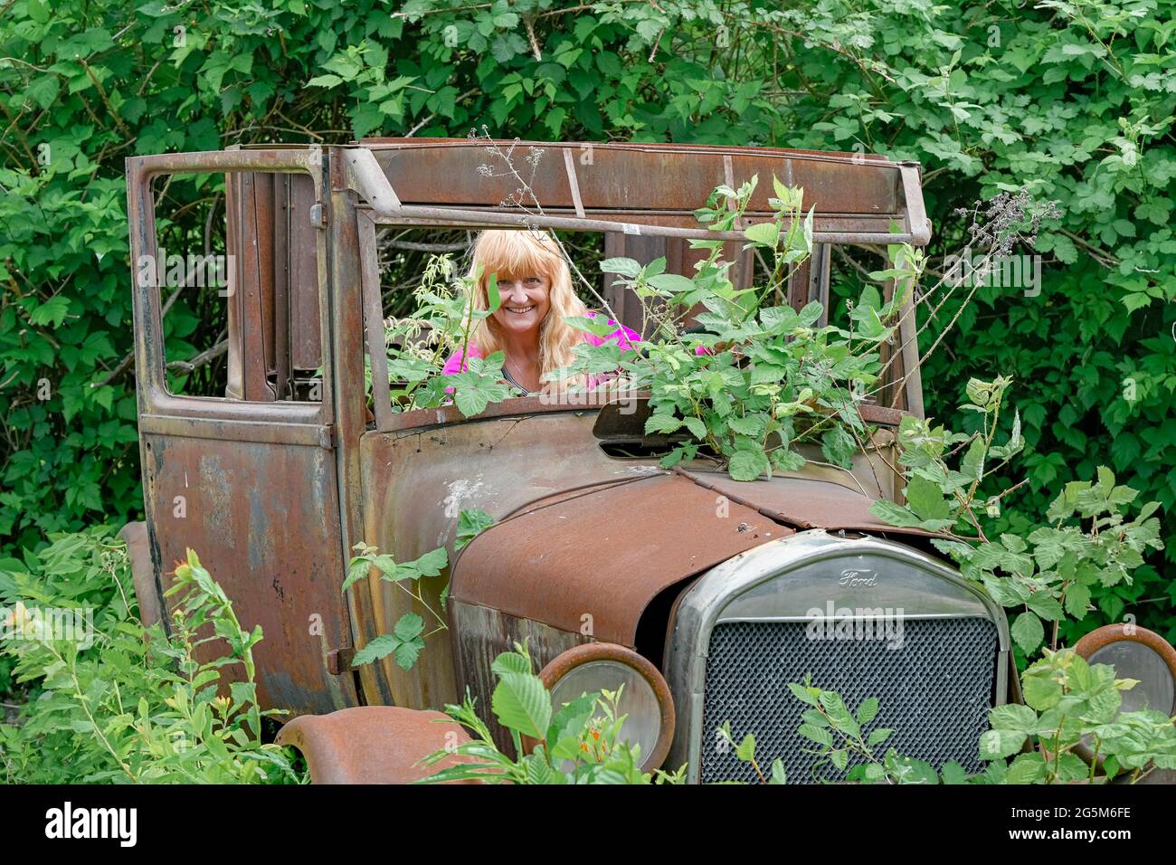 Woman in old rusty car Stock Photo - Alamy