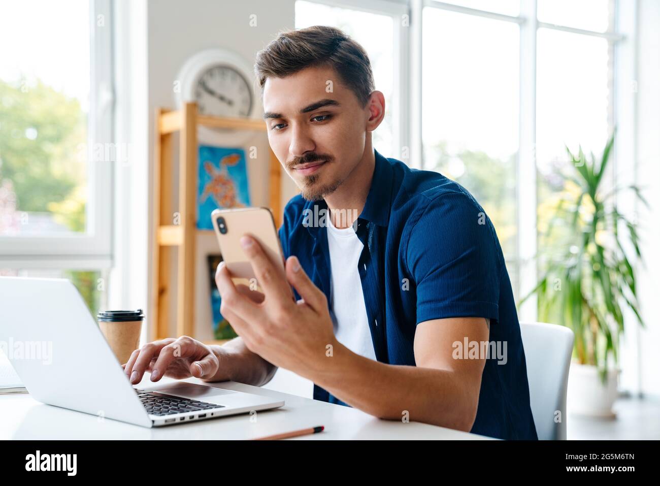 Young designer entrepreneur working on laptop while sittng in his ...