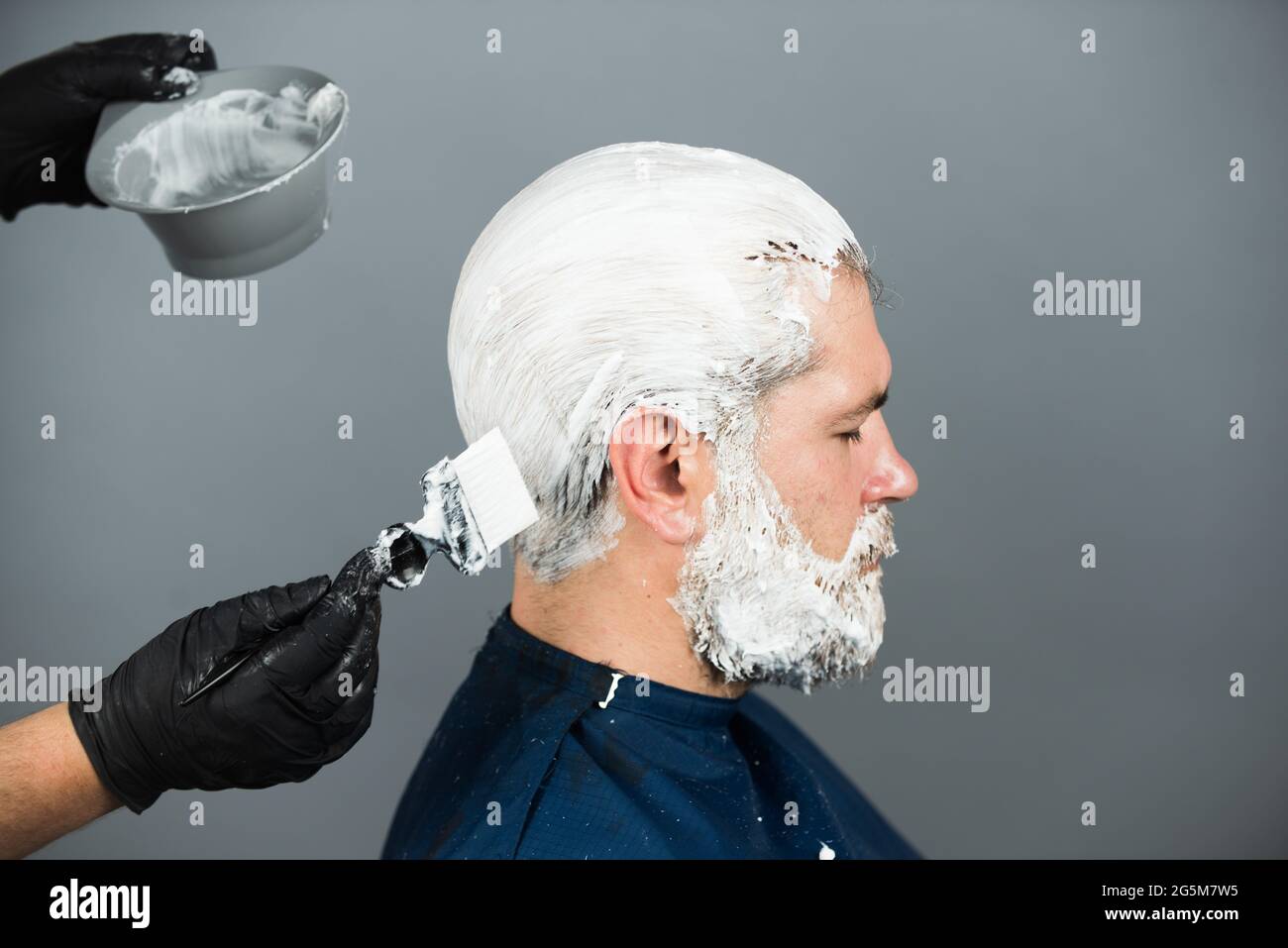 Portrait of bearded man color hair. Process of a man hair coloring at ...