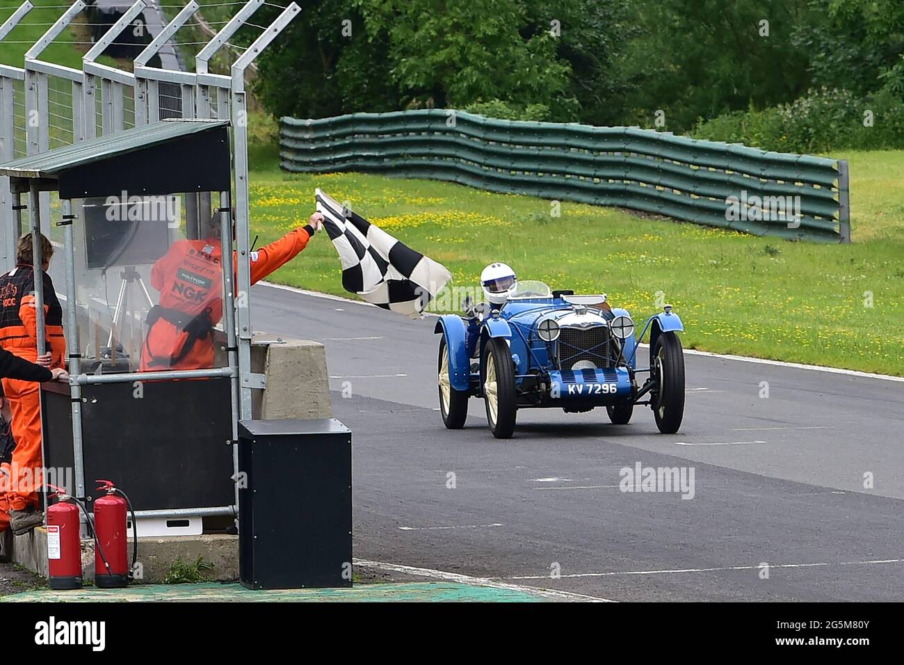 Race winner John Reeve, Riley Brooklands, takes the chequered flag ...