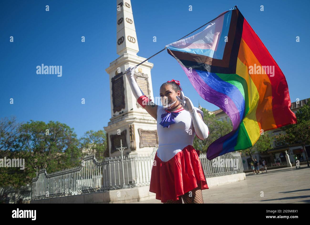 A protester seen holding a pride flag as she poses for a photo during a ...